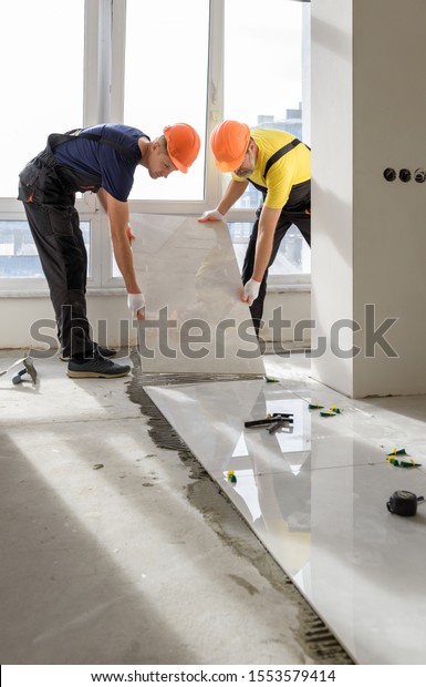 Workers Installing Large Ceramic Tile On Stock Photo (Edit Now) 1553579414