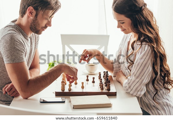 Young Couple Playing Chess While Sitting Stock Photo (Edit Now) 659611840