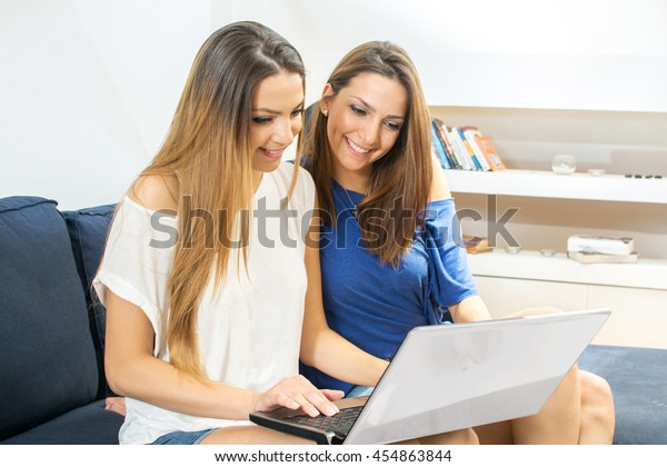 Young Sisters Using Laptop While Sitting Stock Photo 454863844 ...