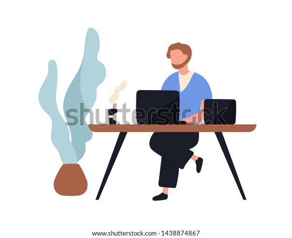 Adorable man sitting at desk and working on laptop computer. Cute young ...