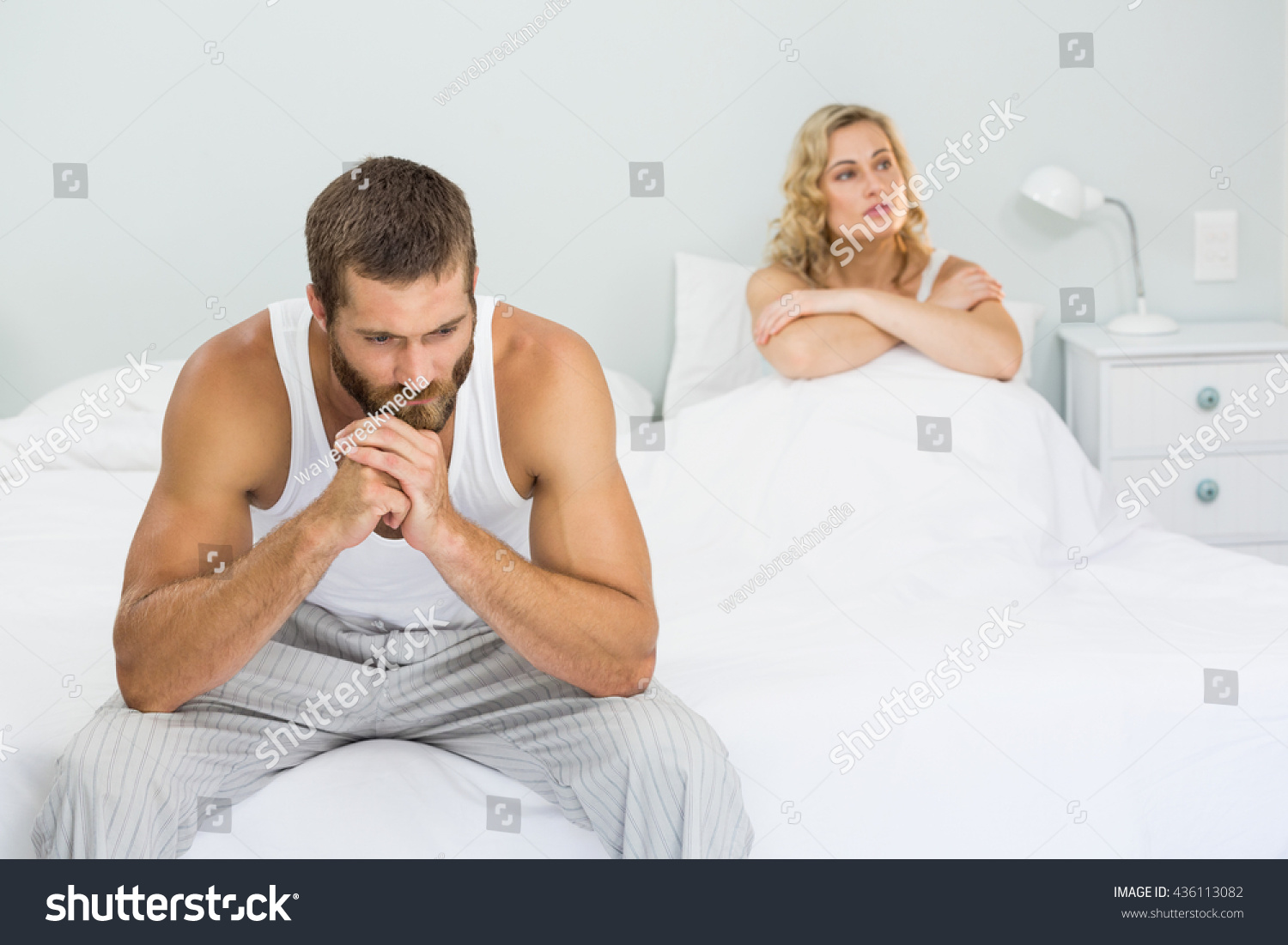 Upset Couple Ignoring Each Other After Fight On Bed In Bedroom Stock